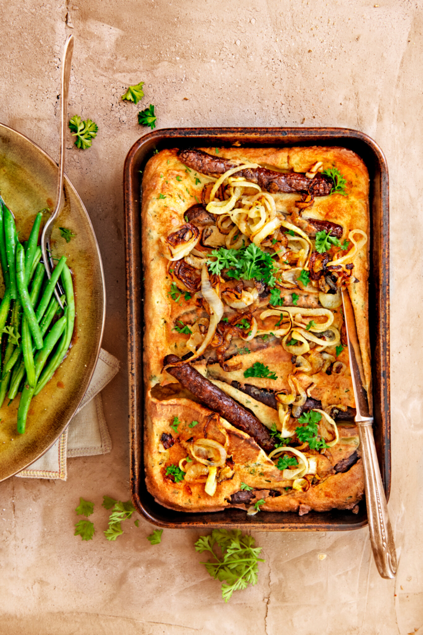 toad-in-the-hole met chipolata, worcester-uien en gebakken sperziebonen ...